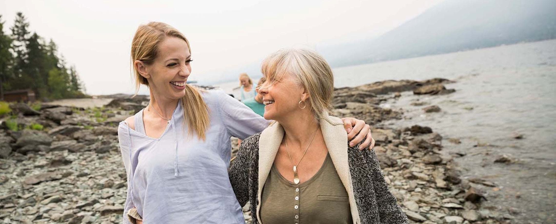 Mother and daughter walking on beach